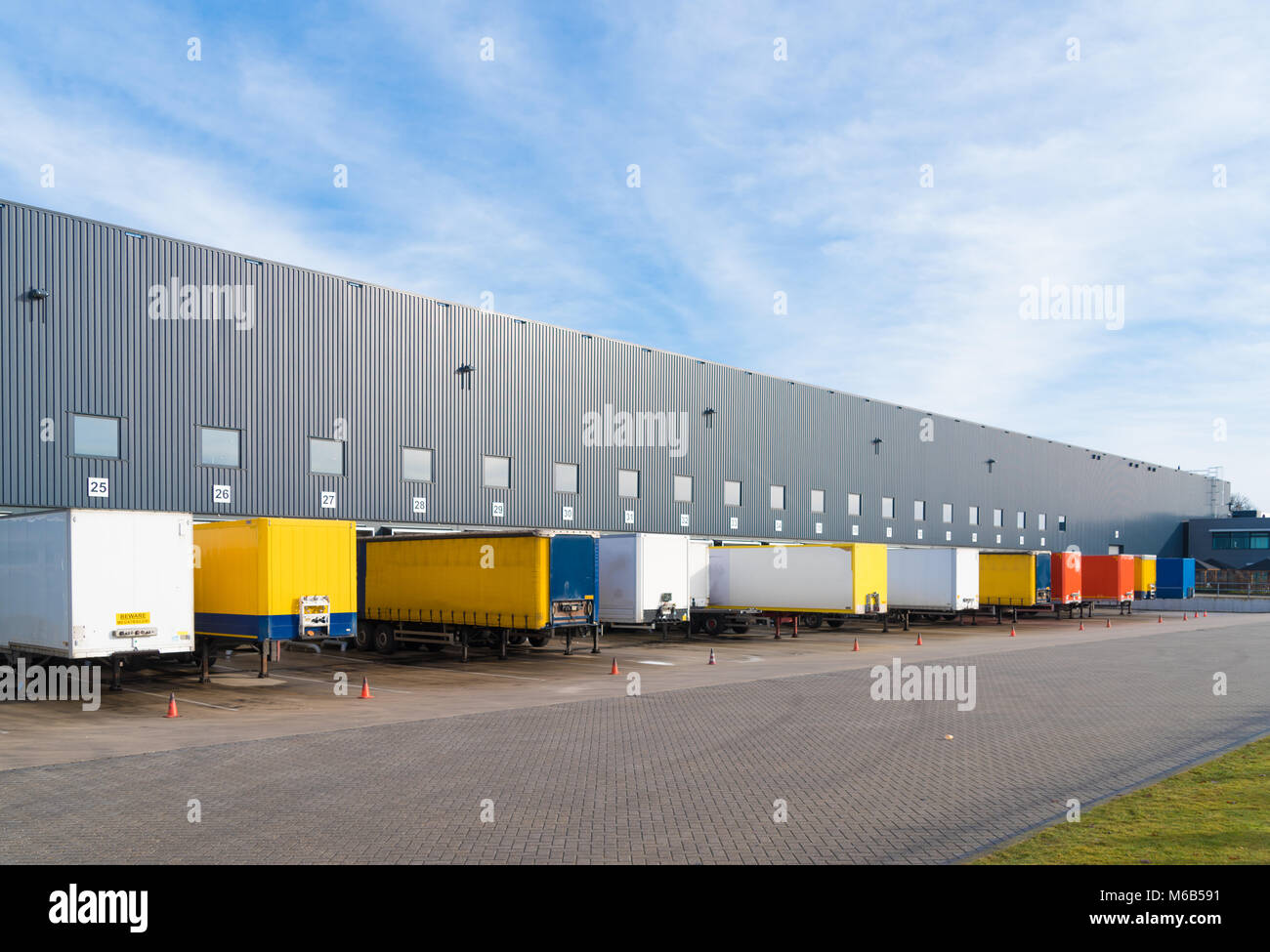 large commercial warehouse with trailers in front Stock Photo - Alamy