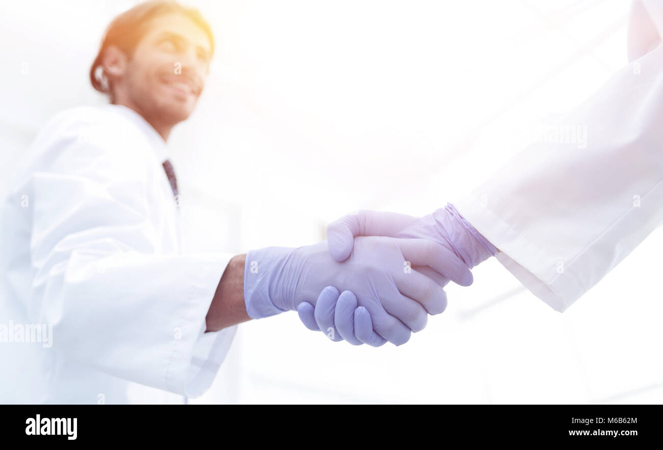 Man doctor shakes hand with another doctor in hospital Stock Photo - Alamy