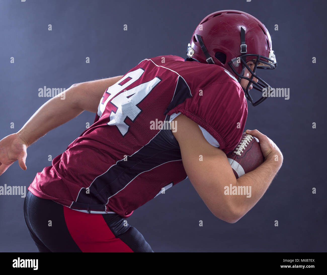 American football Player running with the ball isolated on a gray ...