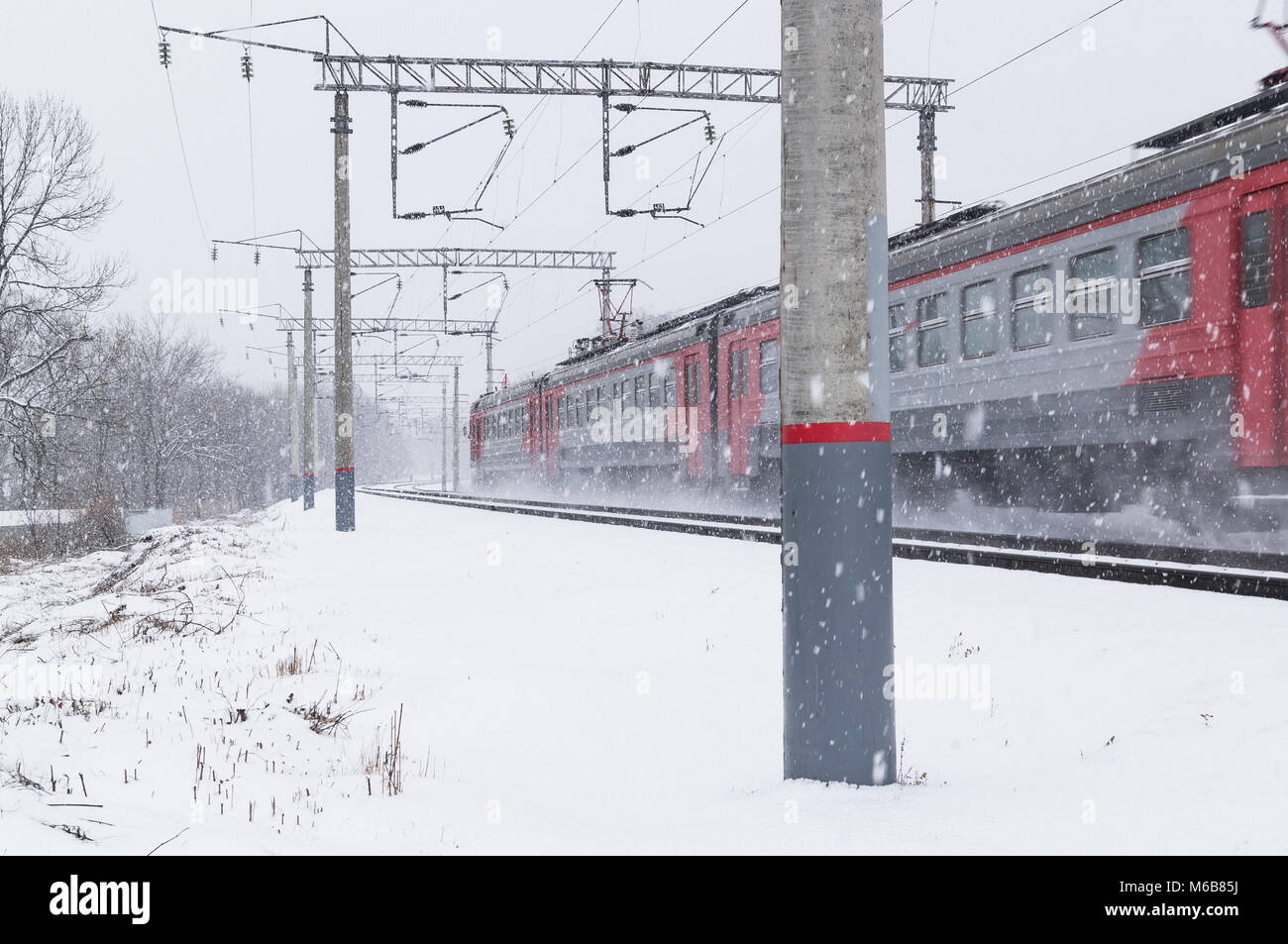 The passenger Russian suburban electric train moves during a blizzard ...