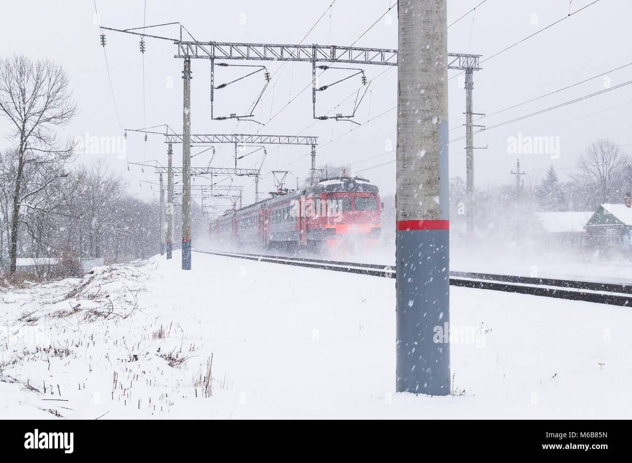 The passenger Russian suburban electric train moves during a blizzard ...