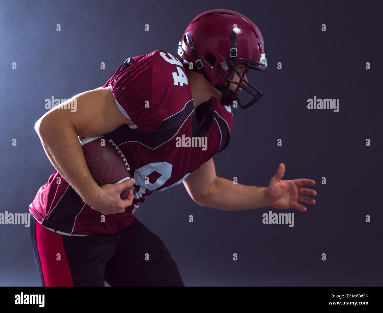 American football Player running with the ball isolated on a gray ...