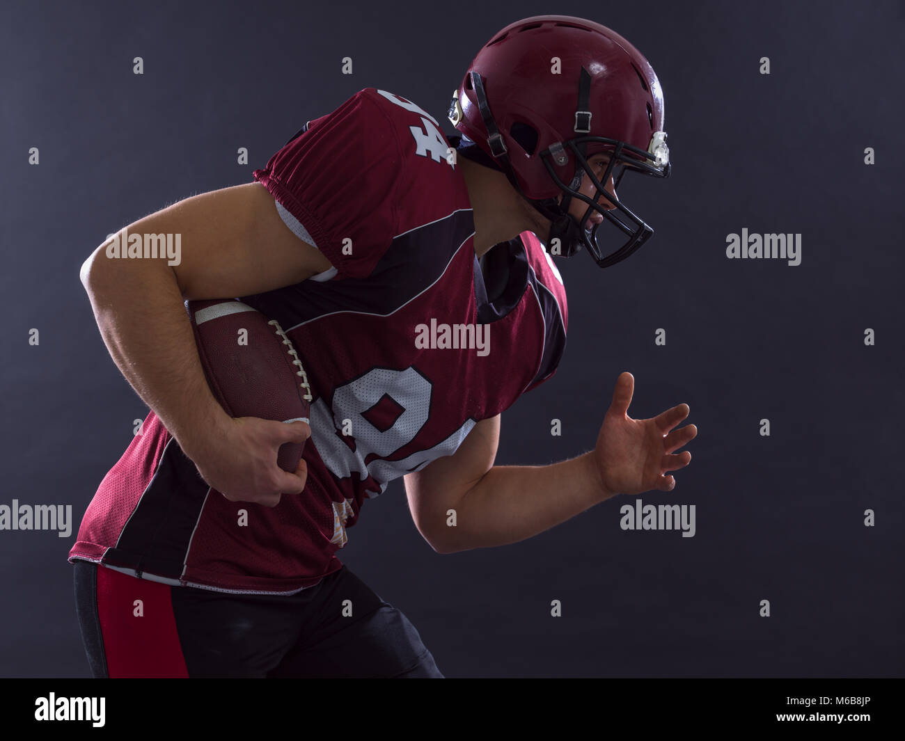 American football Player running with the ball isolated on a gray ...