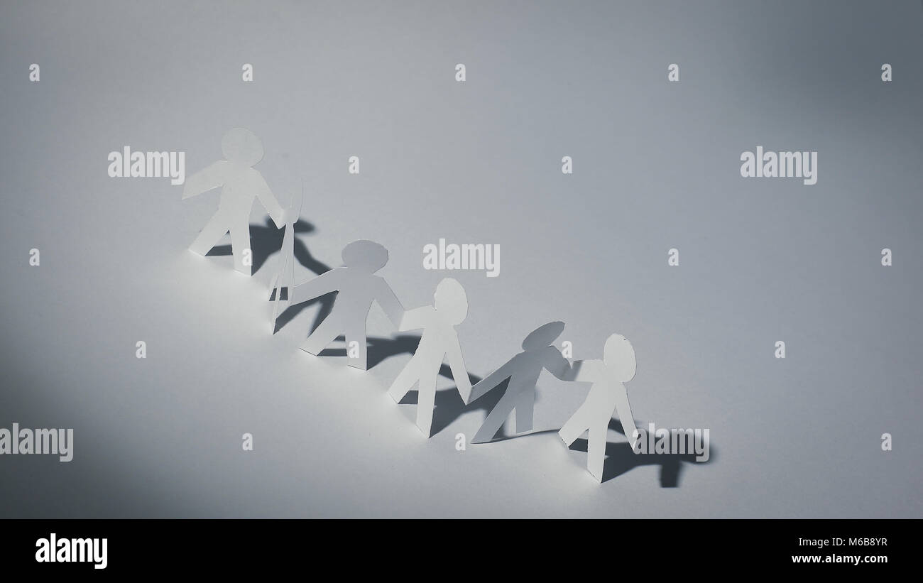 group of paper men holding each other's hands Stock Photo - Alamy