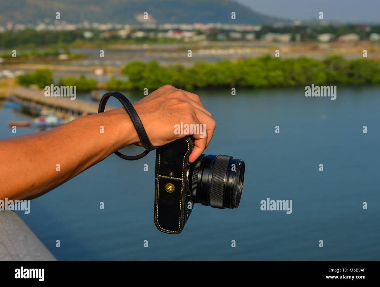 Hand holding a small camera with nature background Stock Photo - Alamy