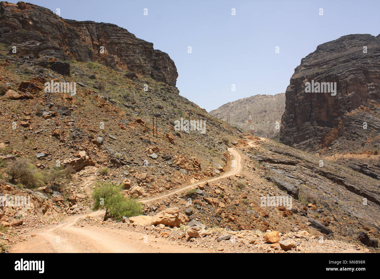 Deserted dirt road leading through a barren landscape of dark rocks in ...