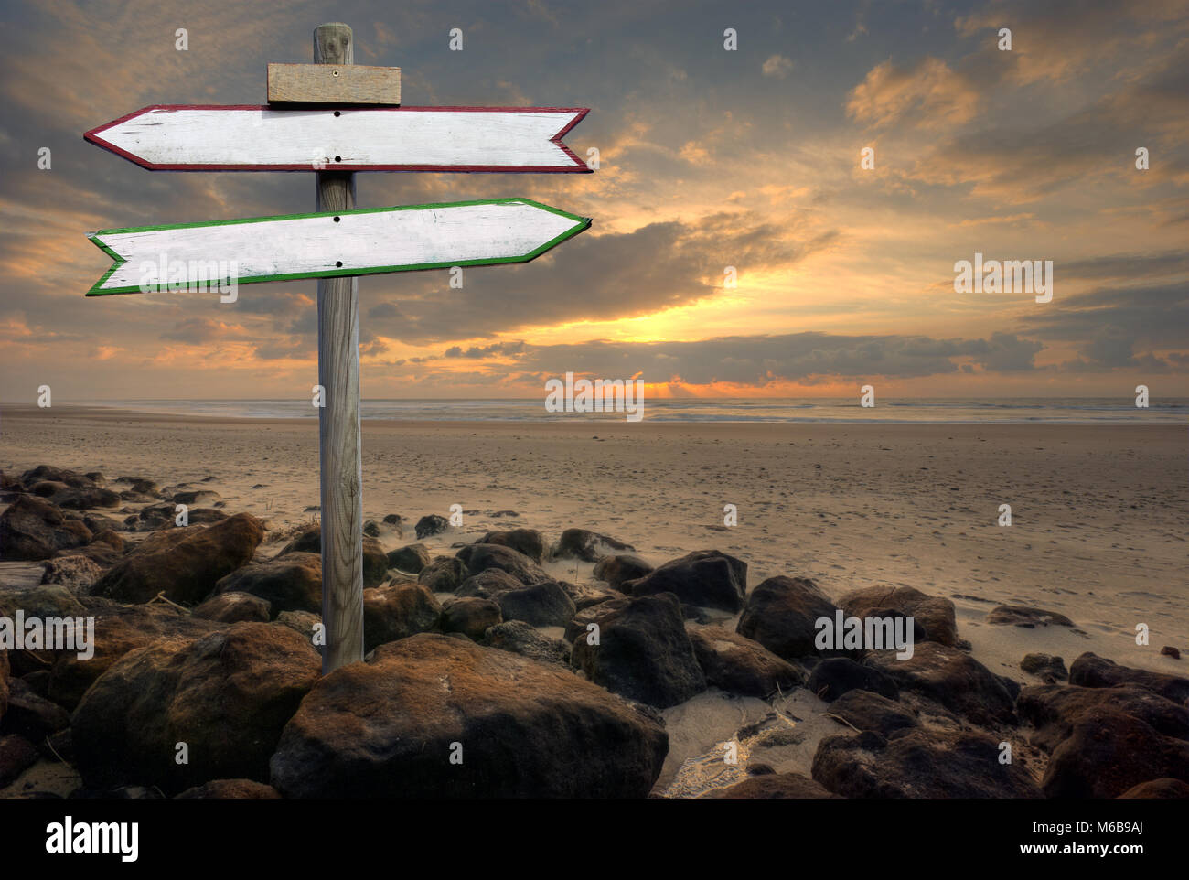 Double directional signs on a beach Stock Photo - Alamy