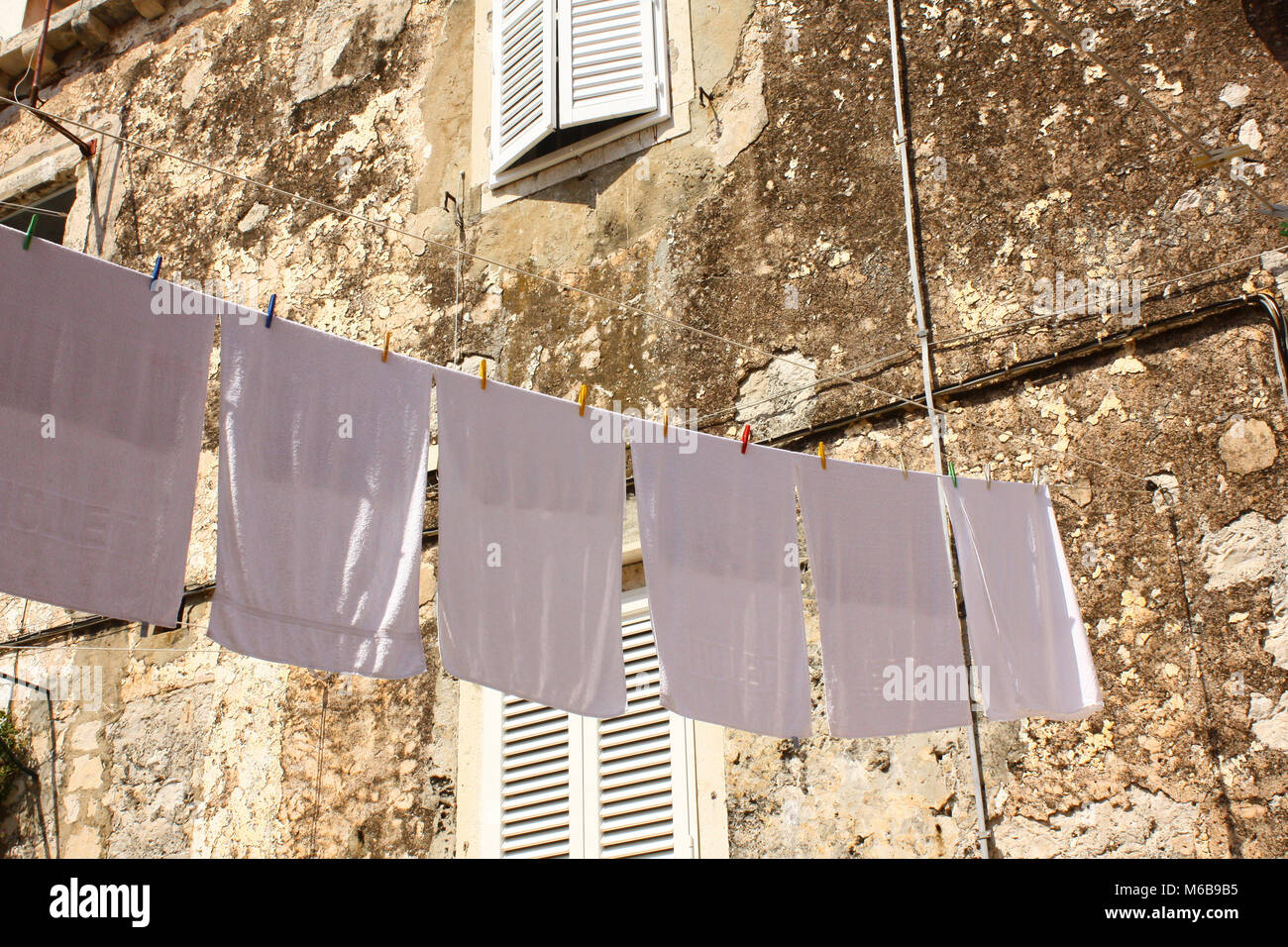 Picturesque washing line with white linen hanging to dry in the ancient ...