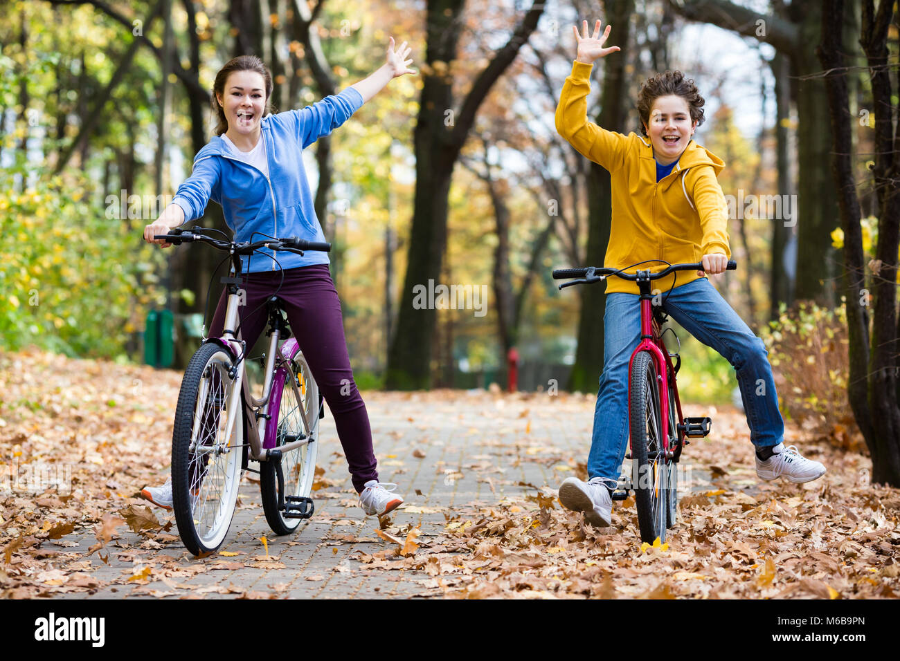 Urban biking - teens riding bikes in city park Stock Photo - Alamy