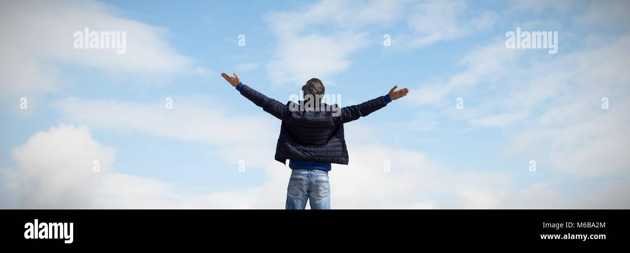 Composite image of rear view of a man raising his arms up Stock Photo ...
