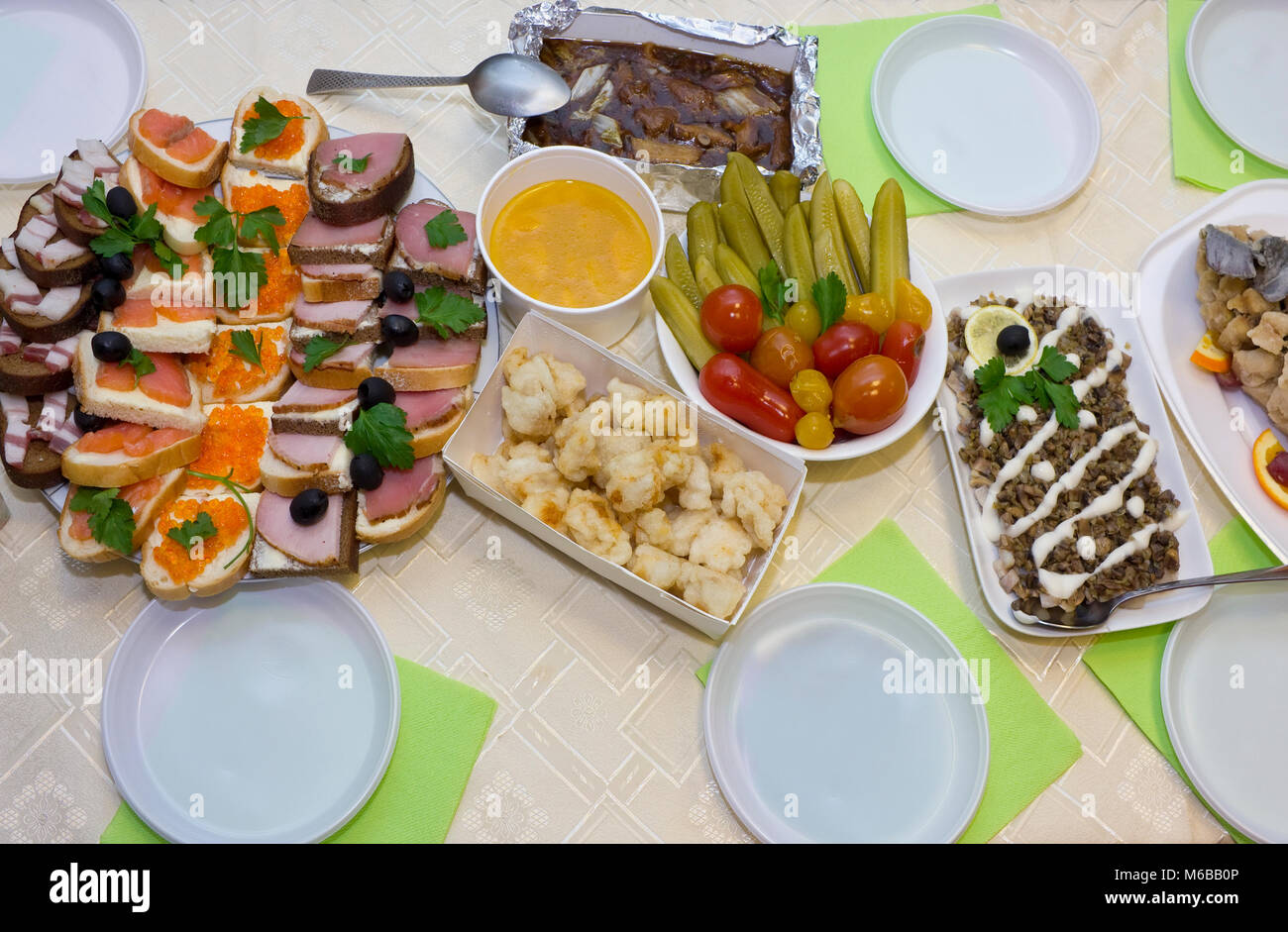A festive table with food and snacks in a poor company. Sandwiches with ...