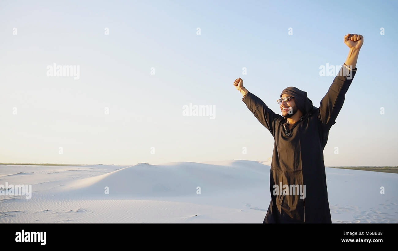 Happy fellow Arabian, walks through desert, smiles and enjoys li Stock ...