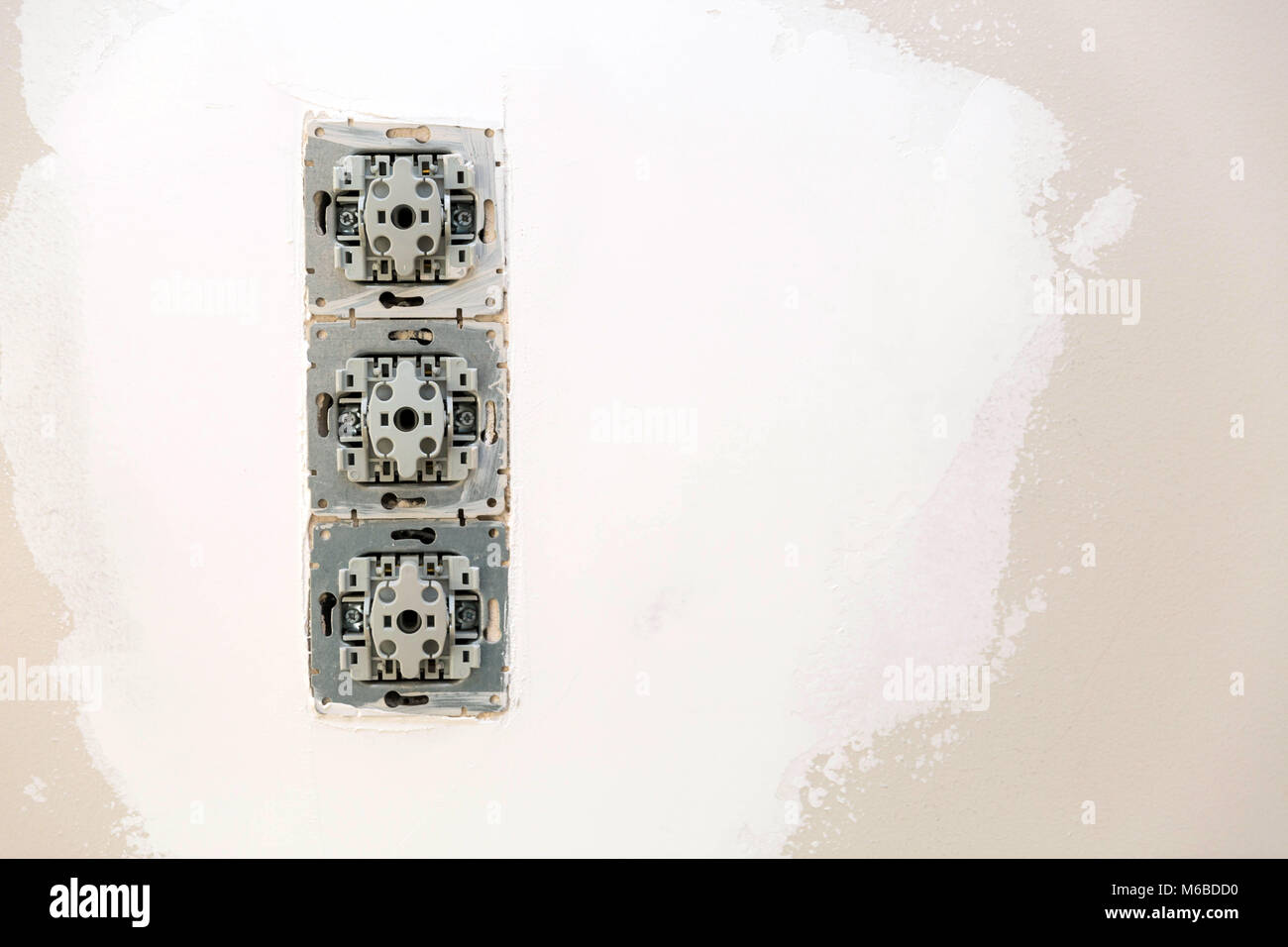 Repairing damaged light switches, installing new Stock Photo - Alamy