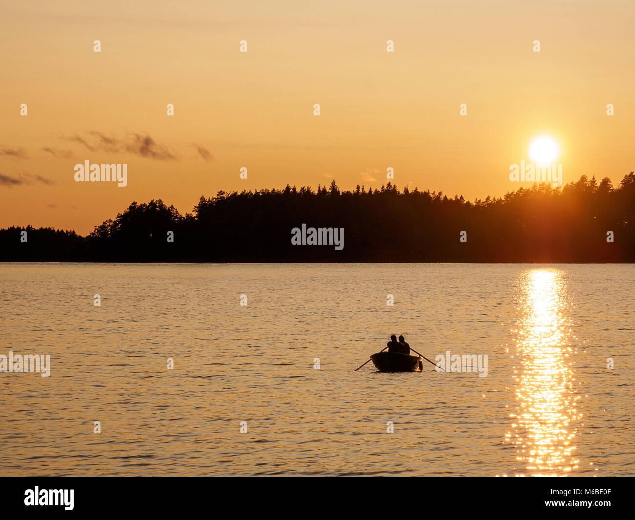 Rowboat at sunset Stock Photo - Alamy