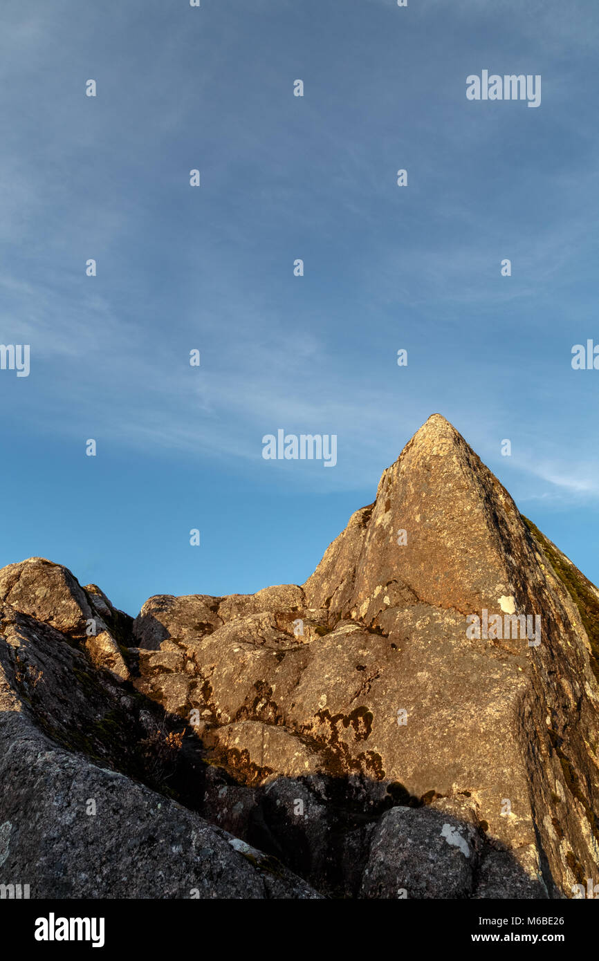 Sun hitting a cliff with blue sky as background Stock Photo - Alamy