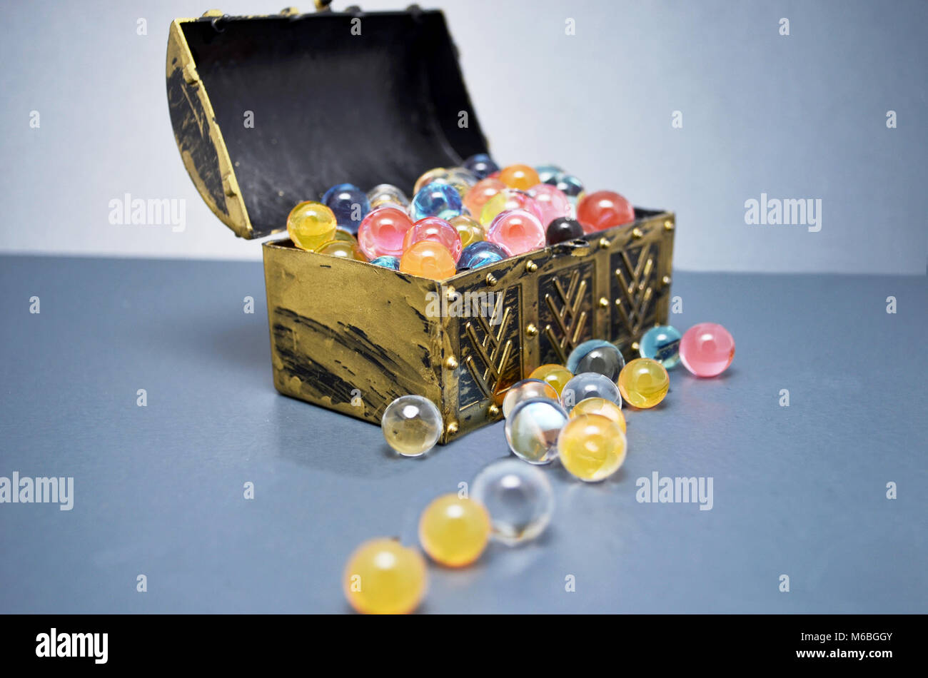 glass balls spilling out of a treasure chest with bokeh Stock Photo - Alamy