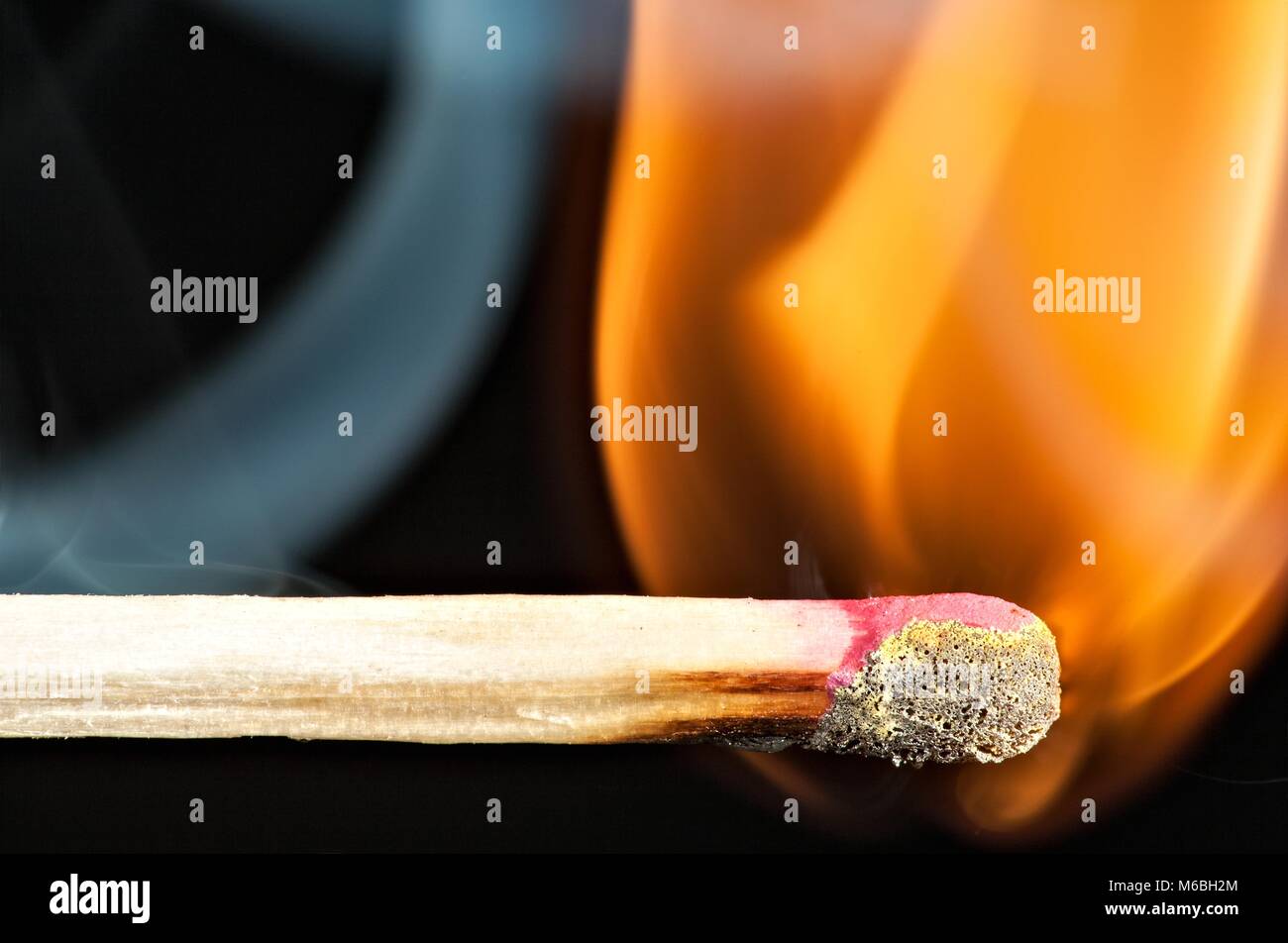 Match with smoke and fire on black Stock Photo - Alamy
