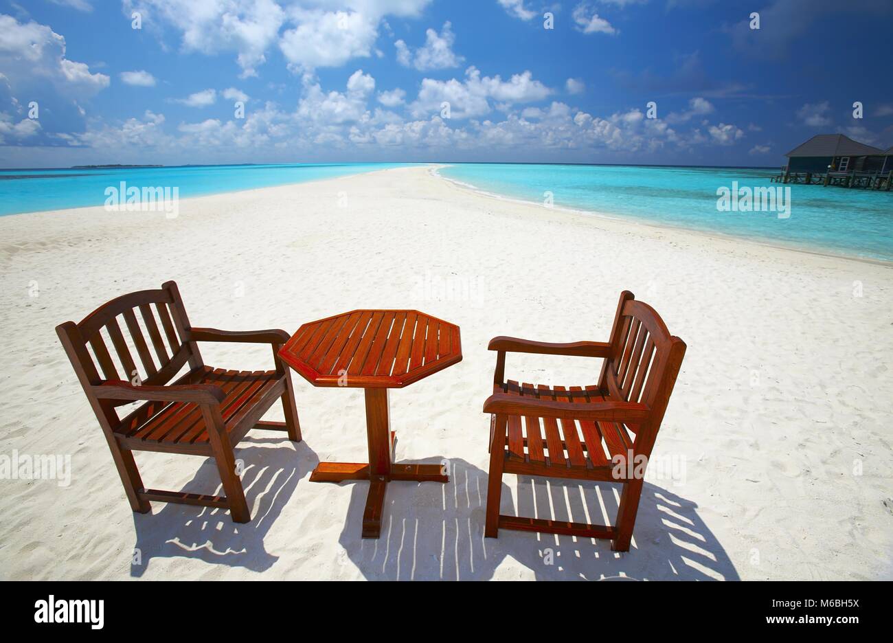 Two chairs and one table are on the coral sandy beach, Maldives Stock ...