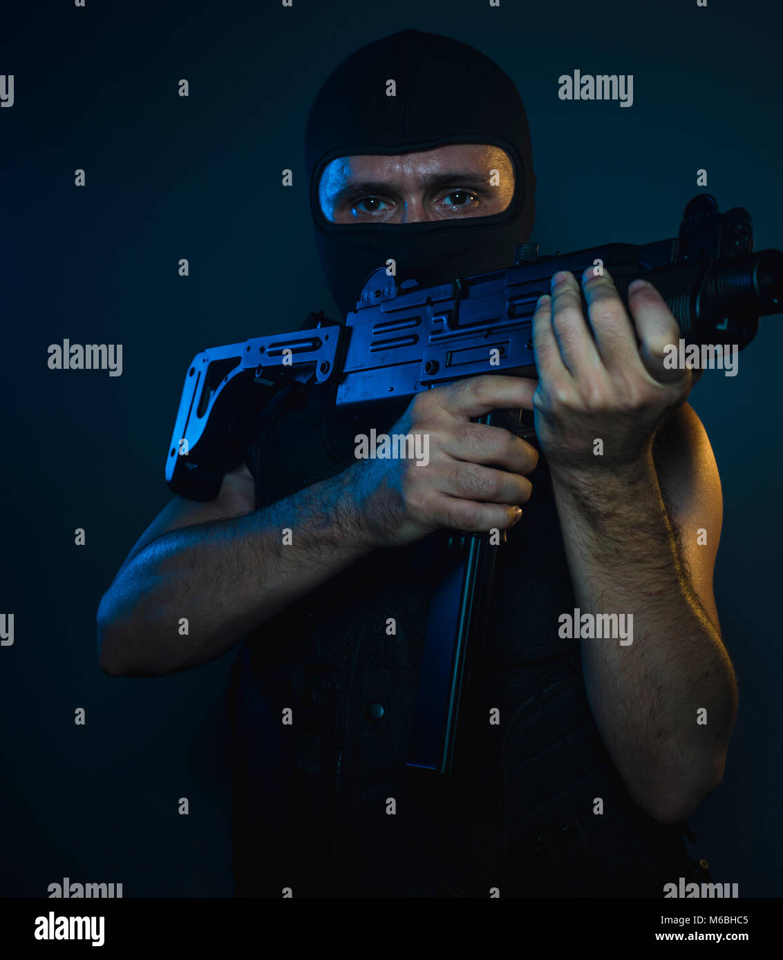 Robber hit man, armed and dangerous man with balaclava and bulletproof ...