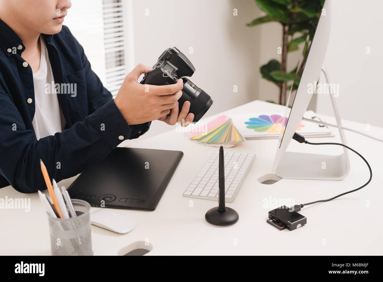 Photographer working at desk in modern office Stock Photo - Alamy