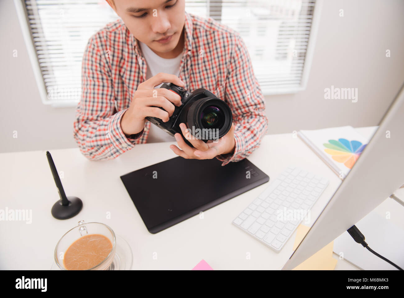 Photographer working at desk in modern office Stock Photo - Alamy