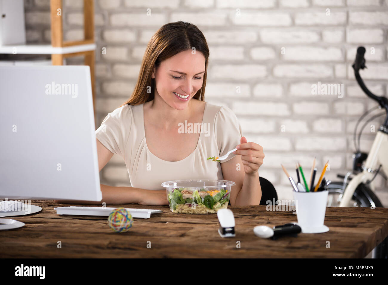 Woman eating salad office desk hi-res stock photography and images - Alamy
