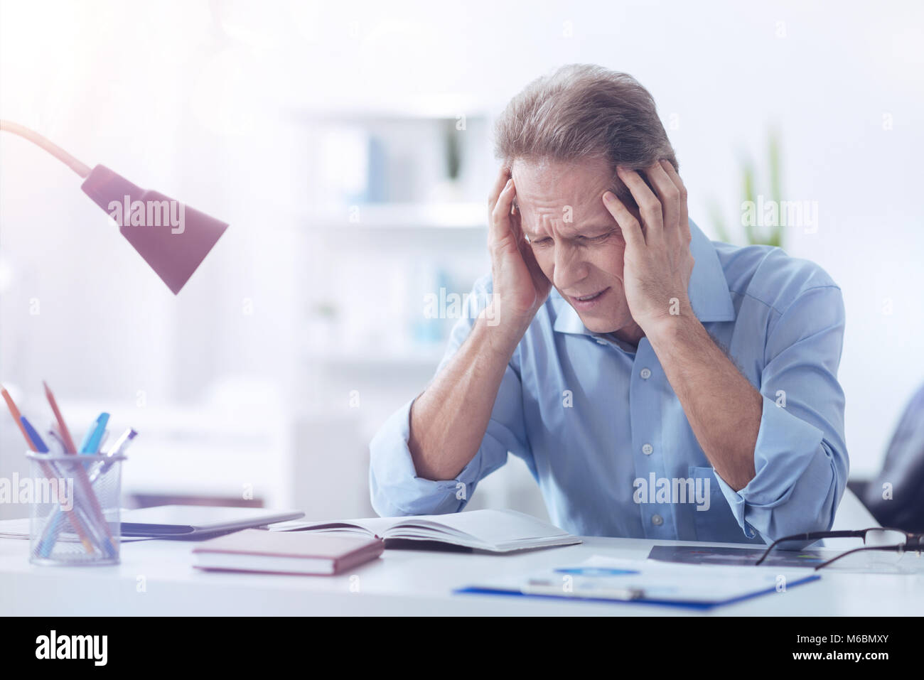 Unhappy sad man holding his head Stock Photo - Alamy
