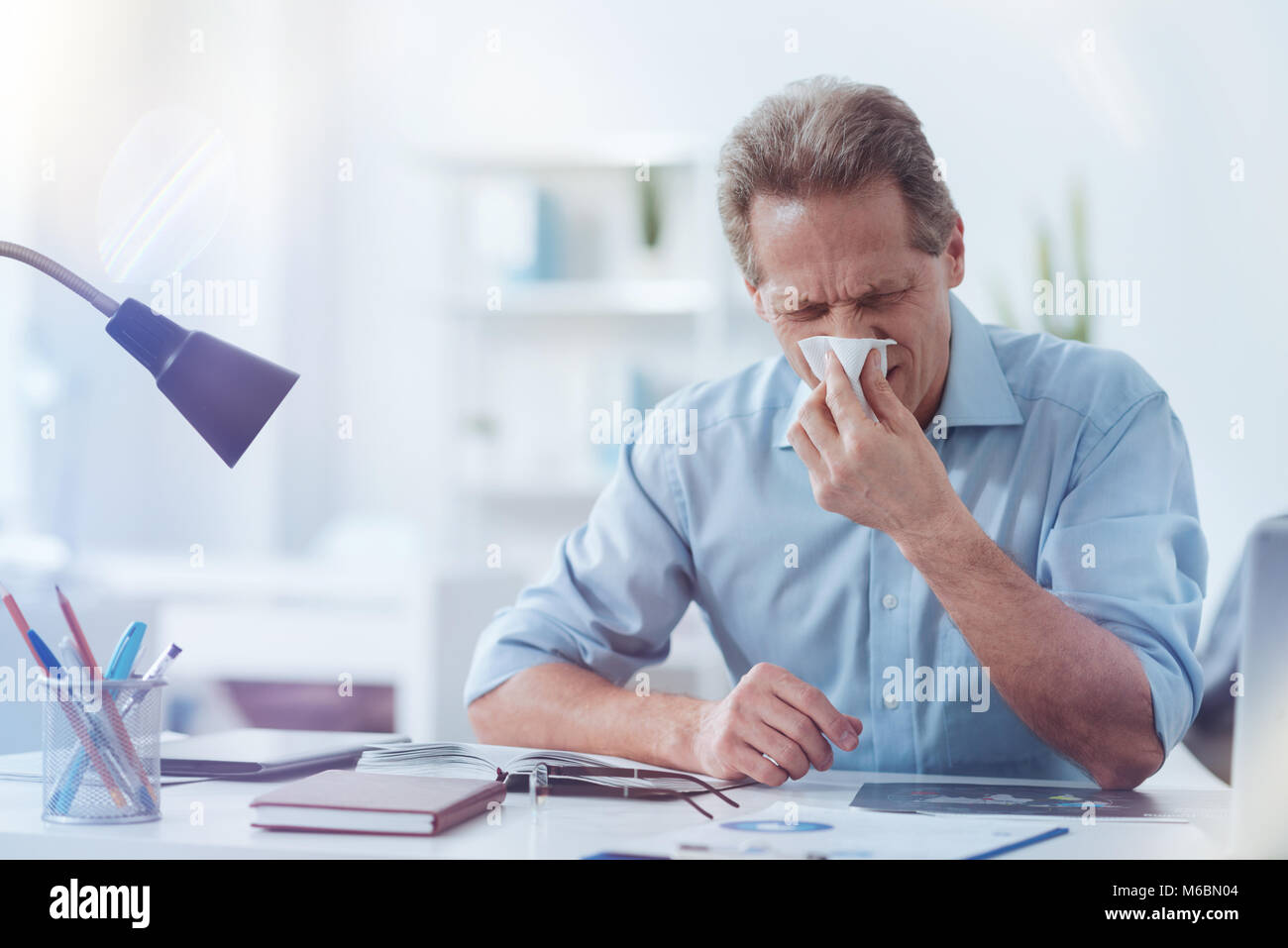 Nice adult man using a paper tissue Stock Photo - Alamy