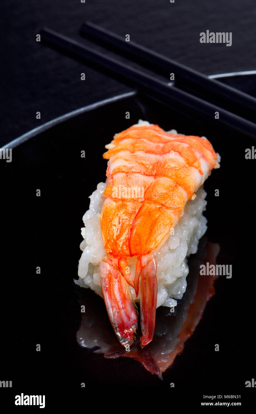 Sushi on a black plate: Nigiri (fish served on top of rice) and ...