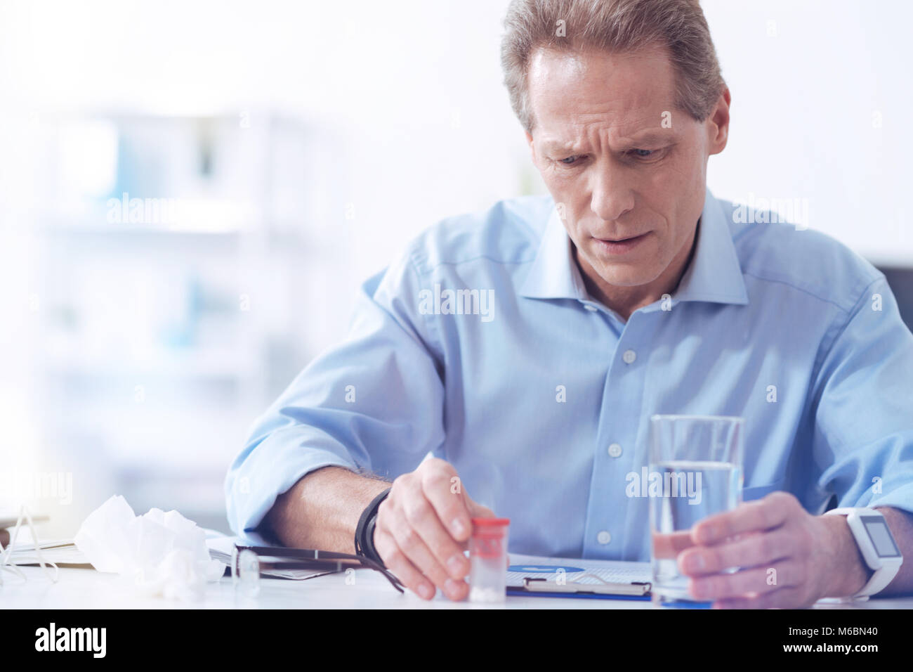 Sad cheerless man being at work Stock Photo - Alamy