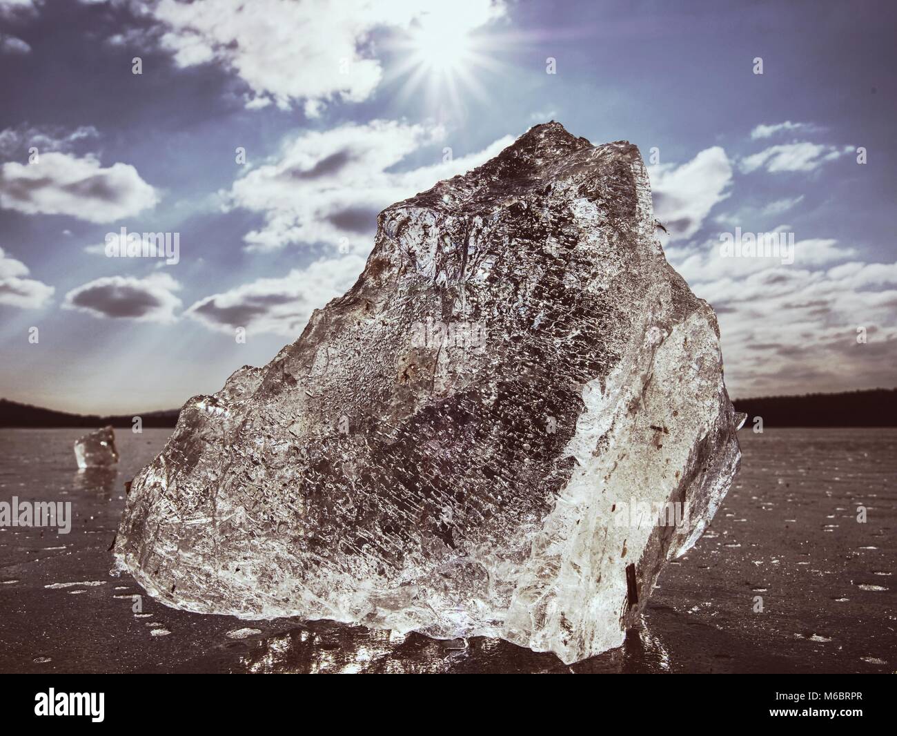 Ice floe at frozen surface with many reflection, blue sky in background ...