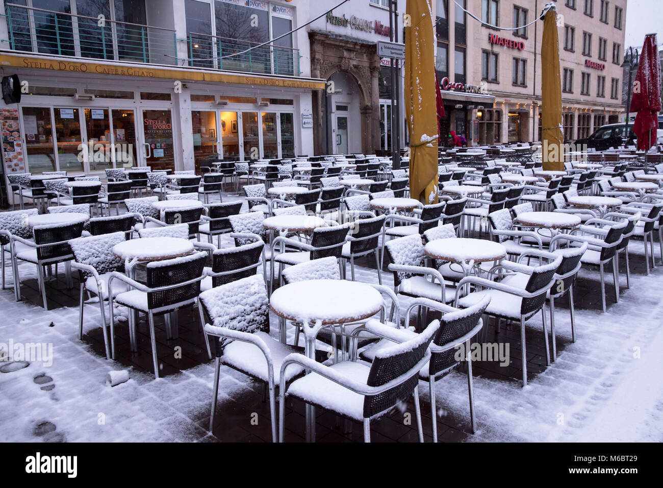 Germany, Cologne, snow covered chairs and tables on the Heumarket ...