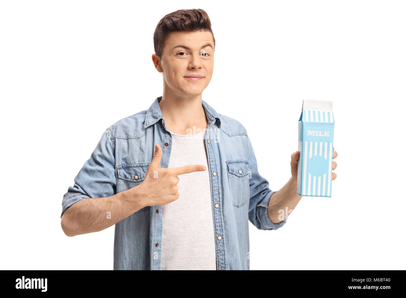 Teenage boy holding a milk carton and pointing isolated on white ...