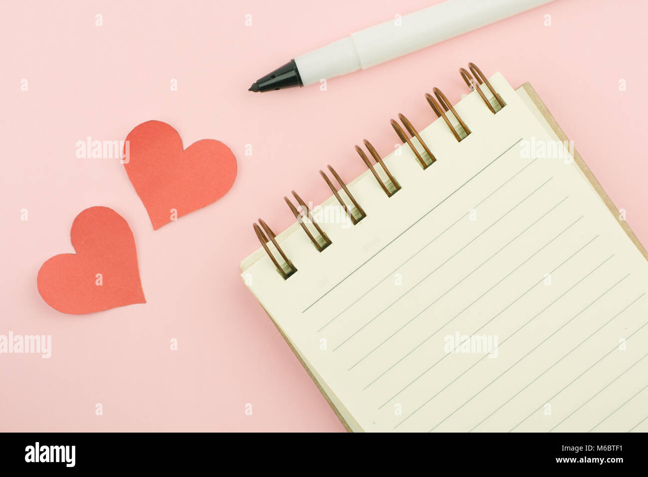 Pen laying and yellow notebook blank on pink background Stock Photo - Alamy