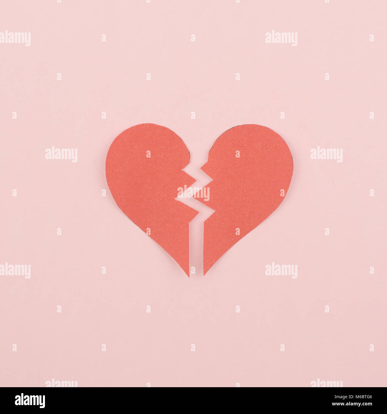 Red heartbreak / broken heart on pink background Stock Photo - Alamy