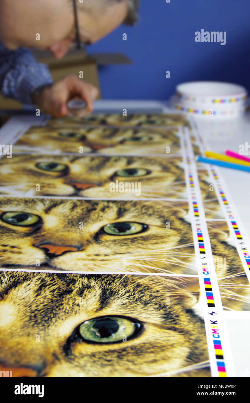 Printer looking at test cmyk registers on printout using magnifier ...