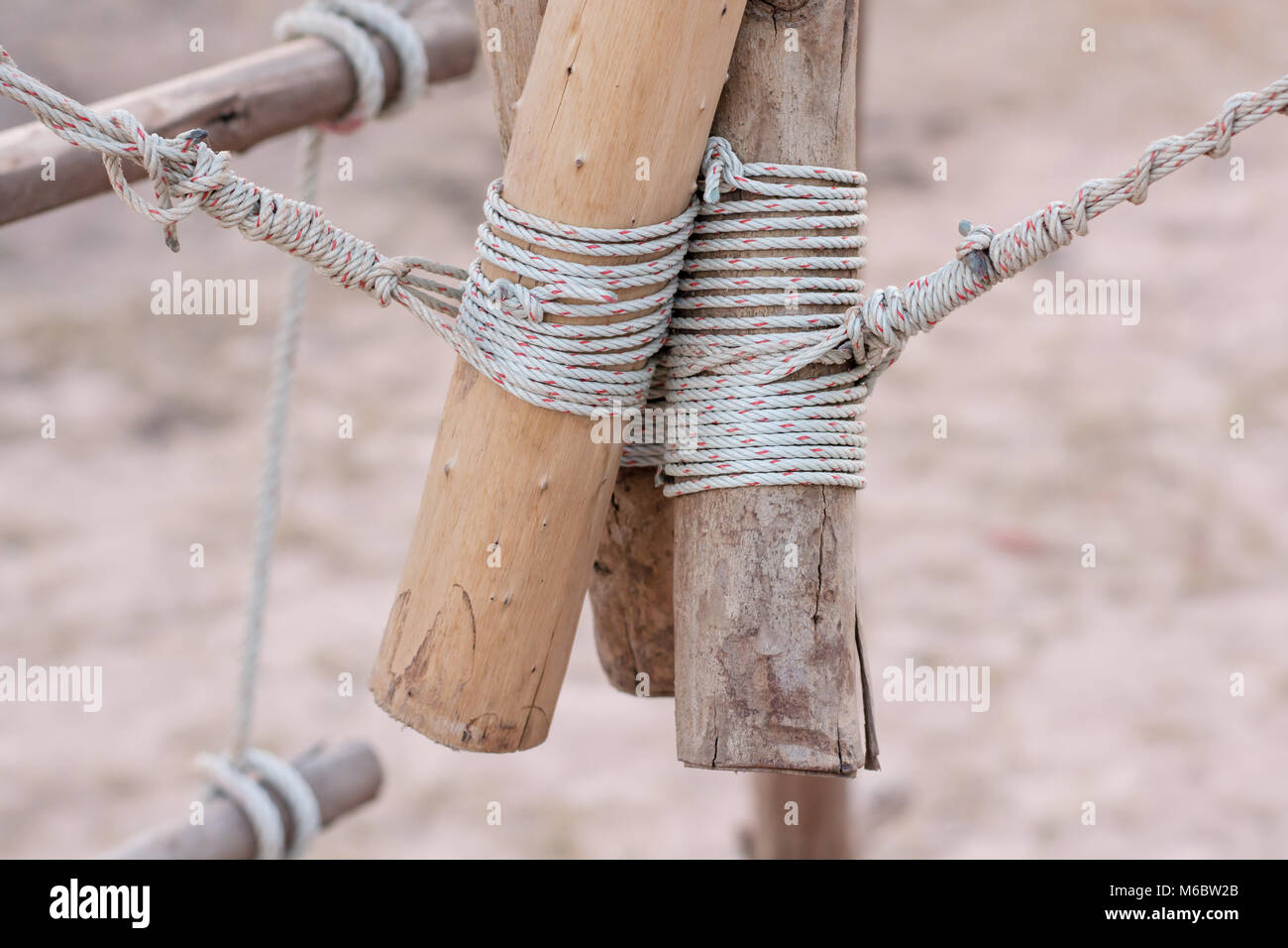 A rope is tied in a knot around a fence post , rope tied knot wood pole ...
