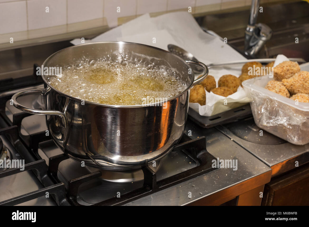 Chef frying food in flaming pan on gas hob in commercial kitchen Stock ...
