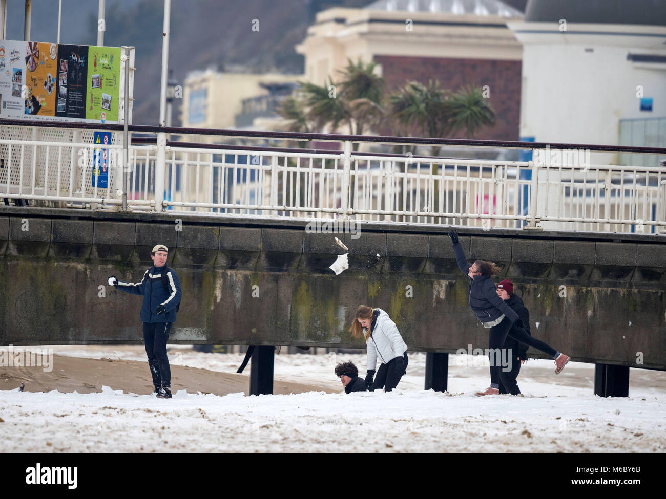 People walk along the snow on Bournemouth beach in Dorset, as extreme ...