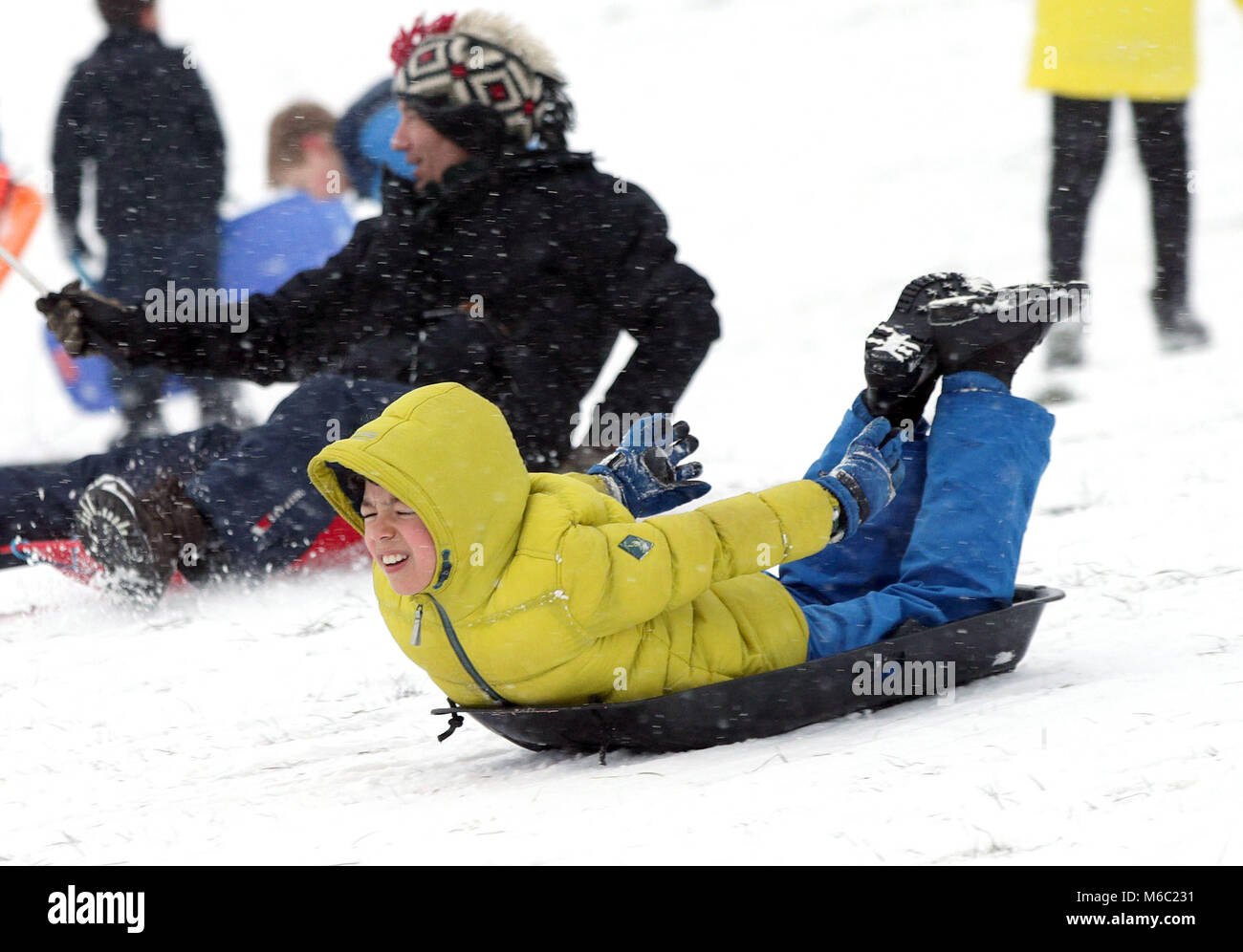 People sledge in the snow at Primrose Hill in London, as the severe ...