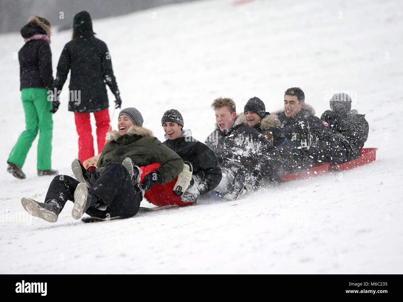 People sledge in the snow at Primrose Hill in London, as the severe ...