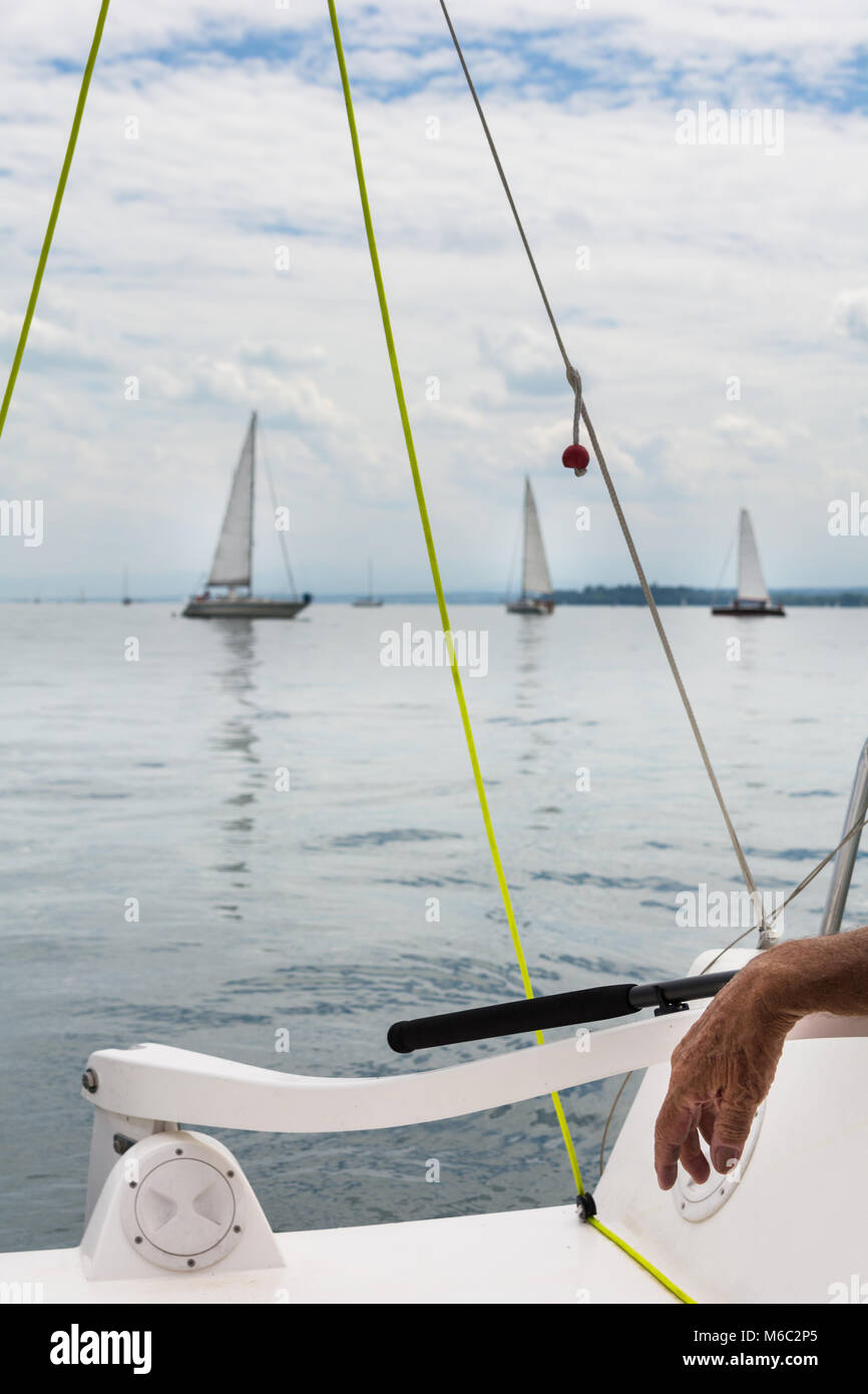 Detail of sailing boat: Hand of an elderly skipper with rig and other ...