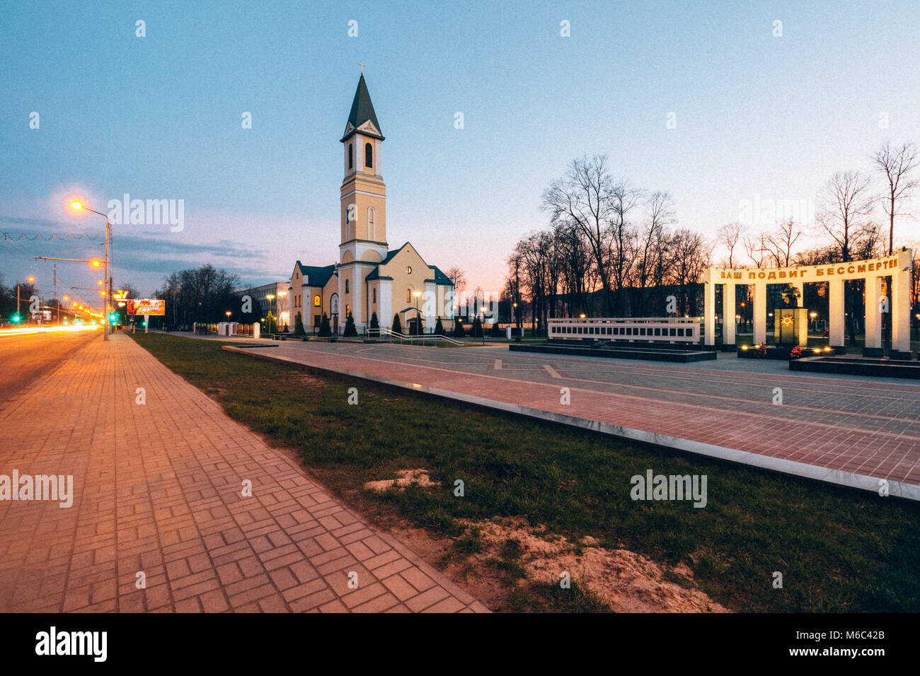 City Roman Catholic church next to the monument of the Red Army soldier ...