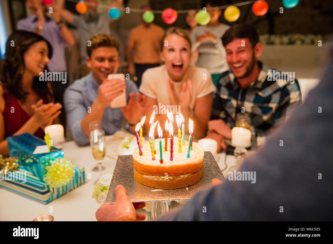 Birthday Cake being brought out to a crowd of people at a birthday ...