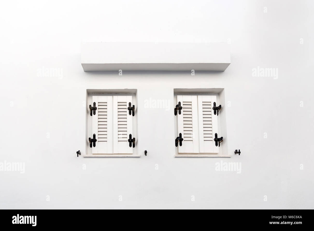 two windows with closed shutters on white wall Stock Photo - Alamy