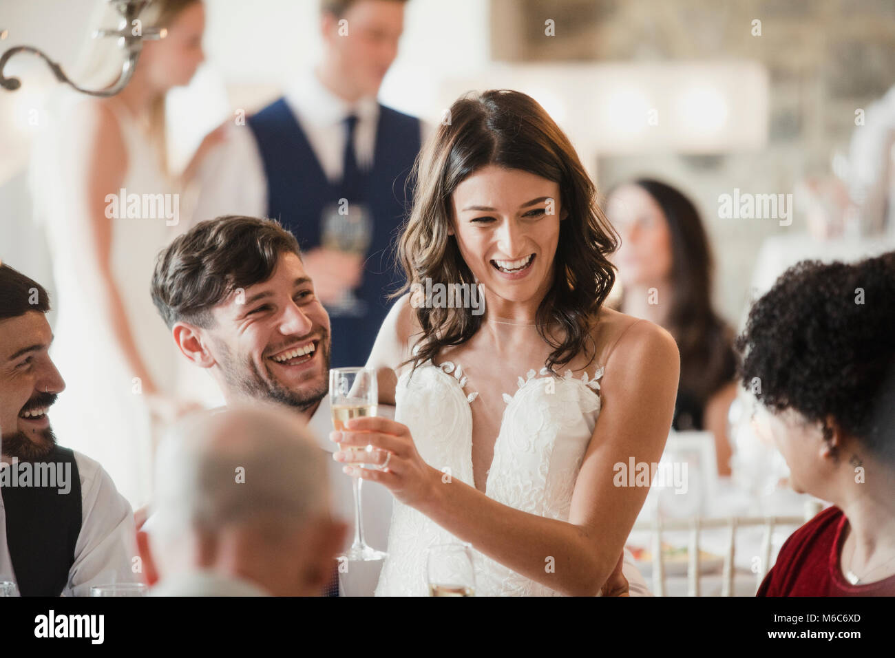 Happy bride and groom are socialising with the guests at their wedding ...