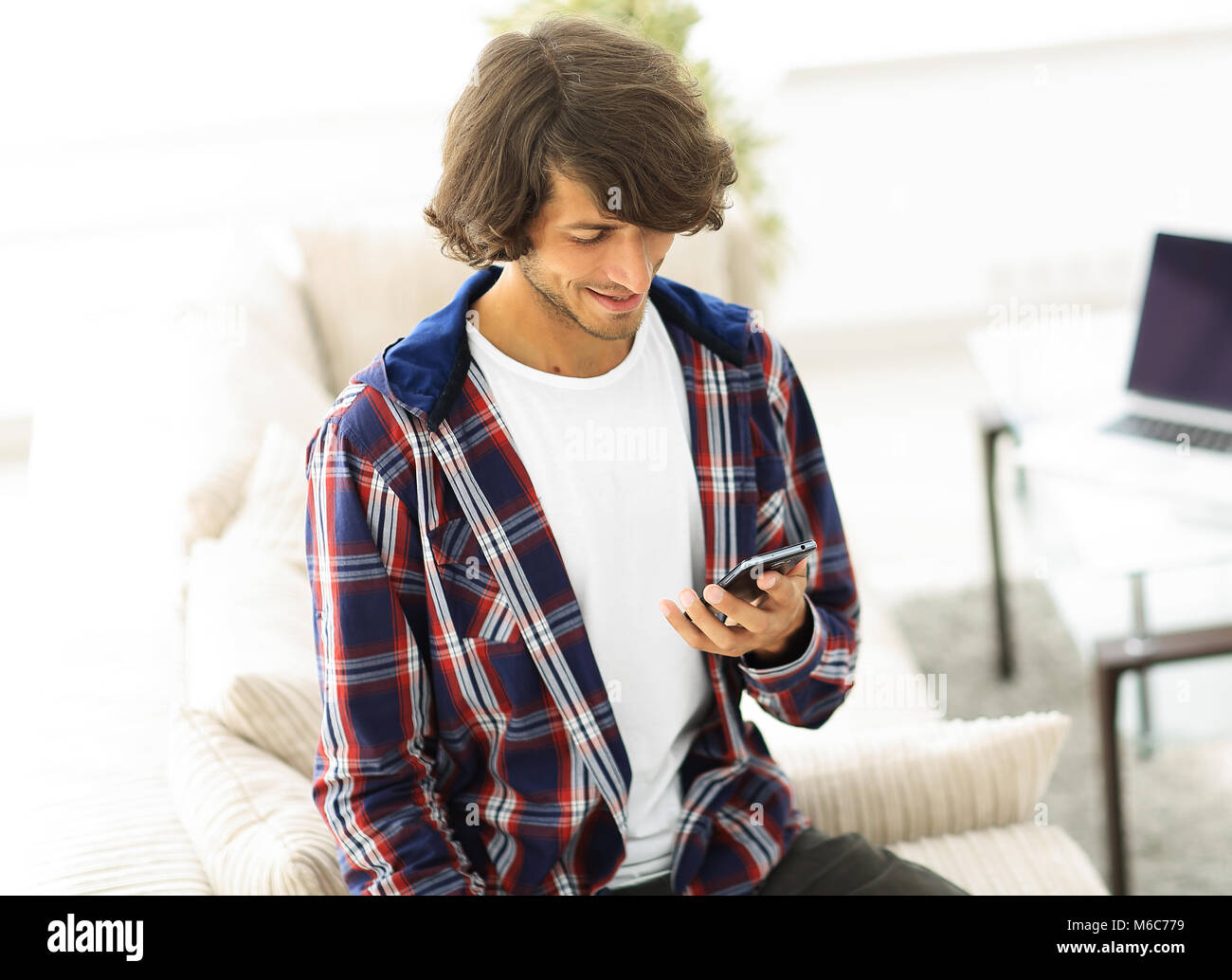 modern guy looking at screen smartphone at home Stock Photo - Alamy