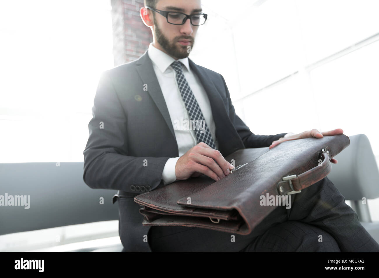 businessman's hand with suitecase in a modern office Stock Photo - Alamy
