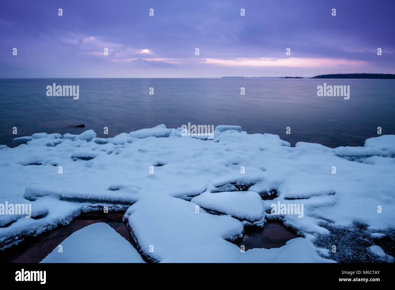 Ice and snow on a lake at sunset Stock Photo - Alamy