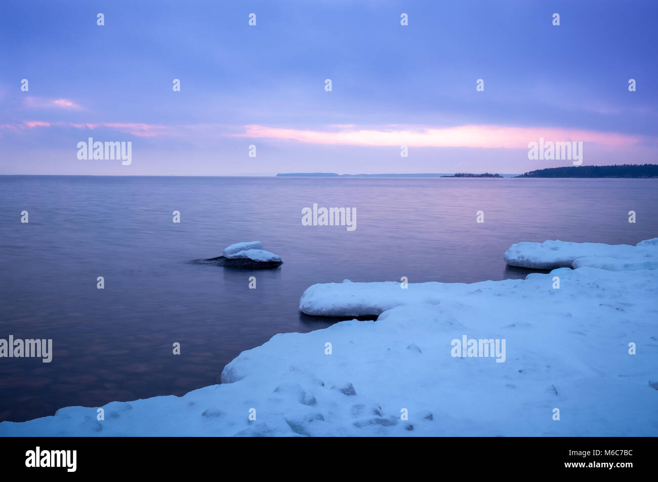 Ice and snow on a lake at sunset Stock Photo - Alamy